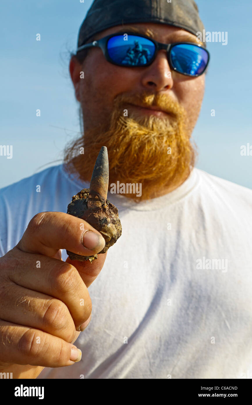 Oyster fisherman holds large bullet embedded in oyster shell Stock ...