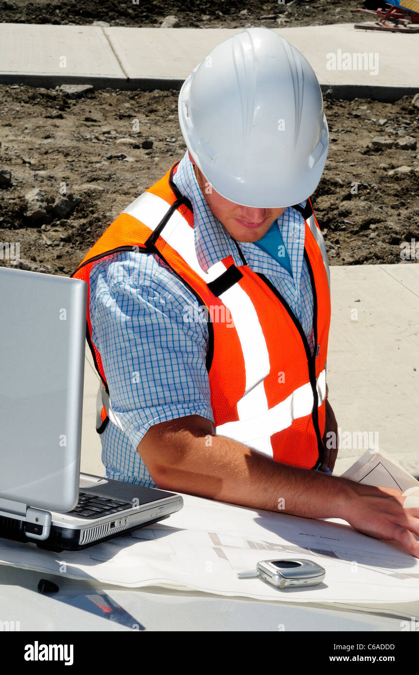 Architect On Site Checking Drawings On His Laptop Computer Stock Photo ...