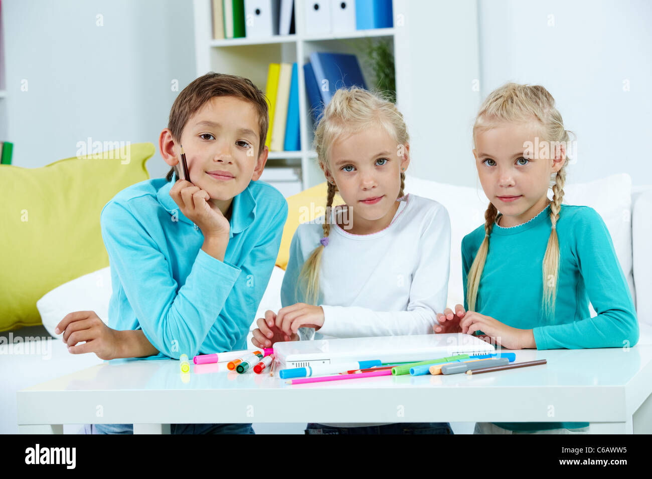 Smart schoolboy and twin girls looking at camera Stock Photo - Alamy