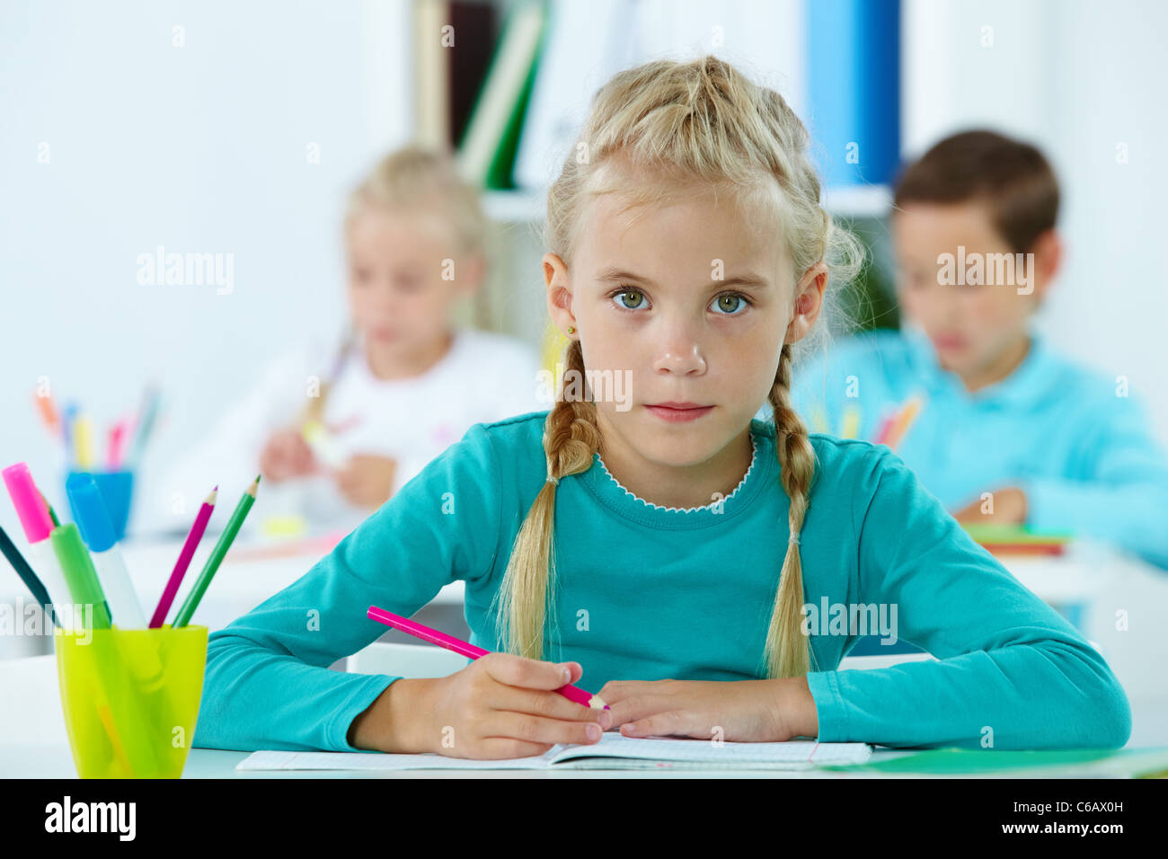 Portrait of lovely girl drawing with classmates on background Stock ...