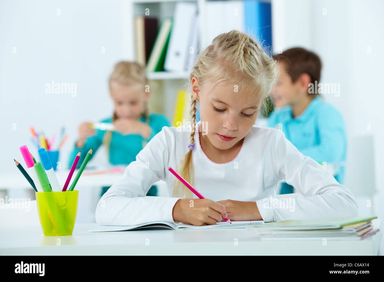 Portrait of lovely girl drawing with classmates on background Stock ...