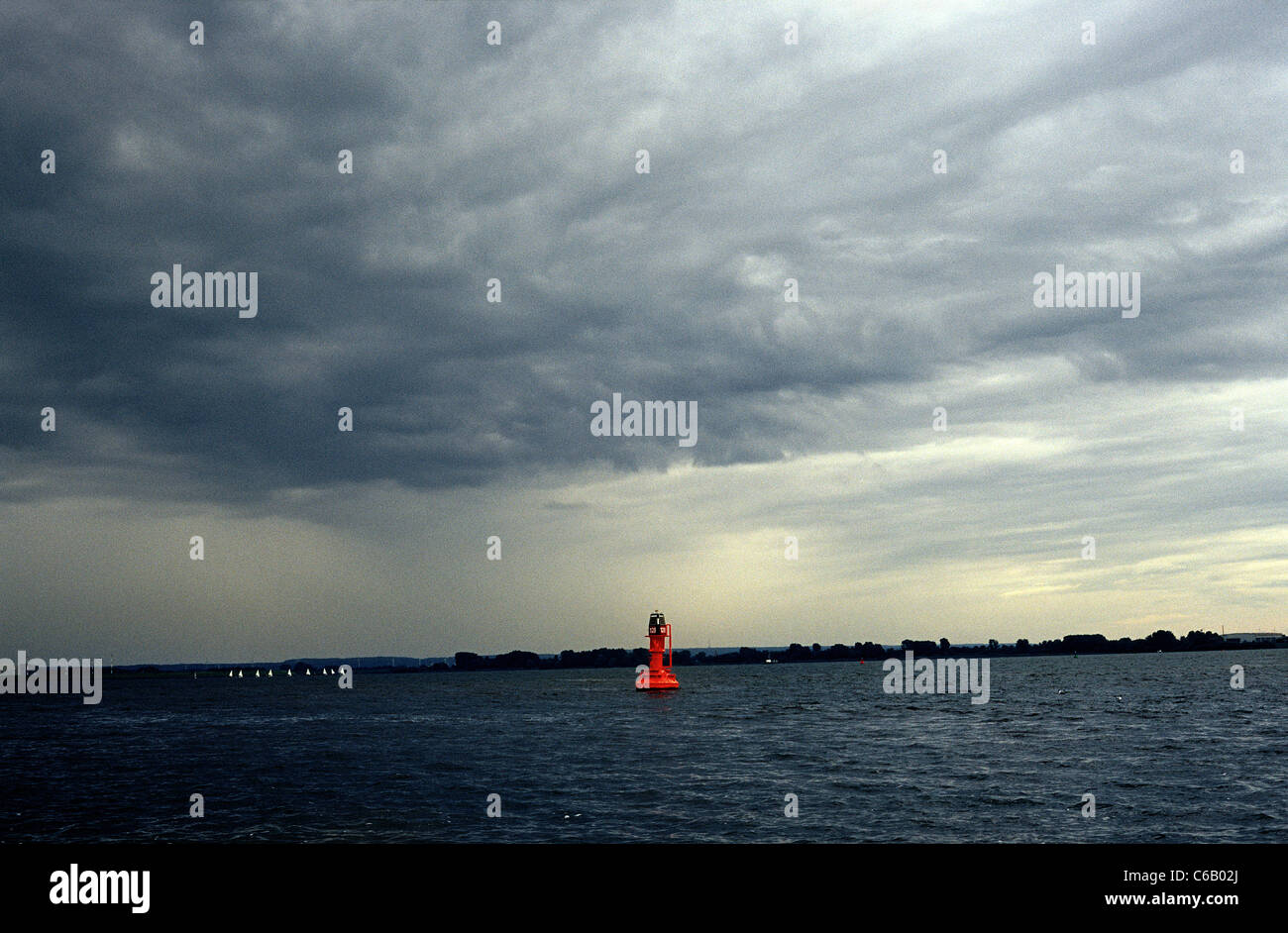 Orange coloured navigational buoy marking the shipping fairway on the ...