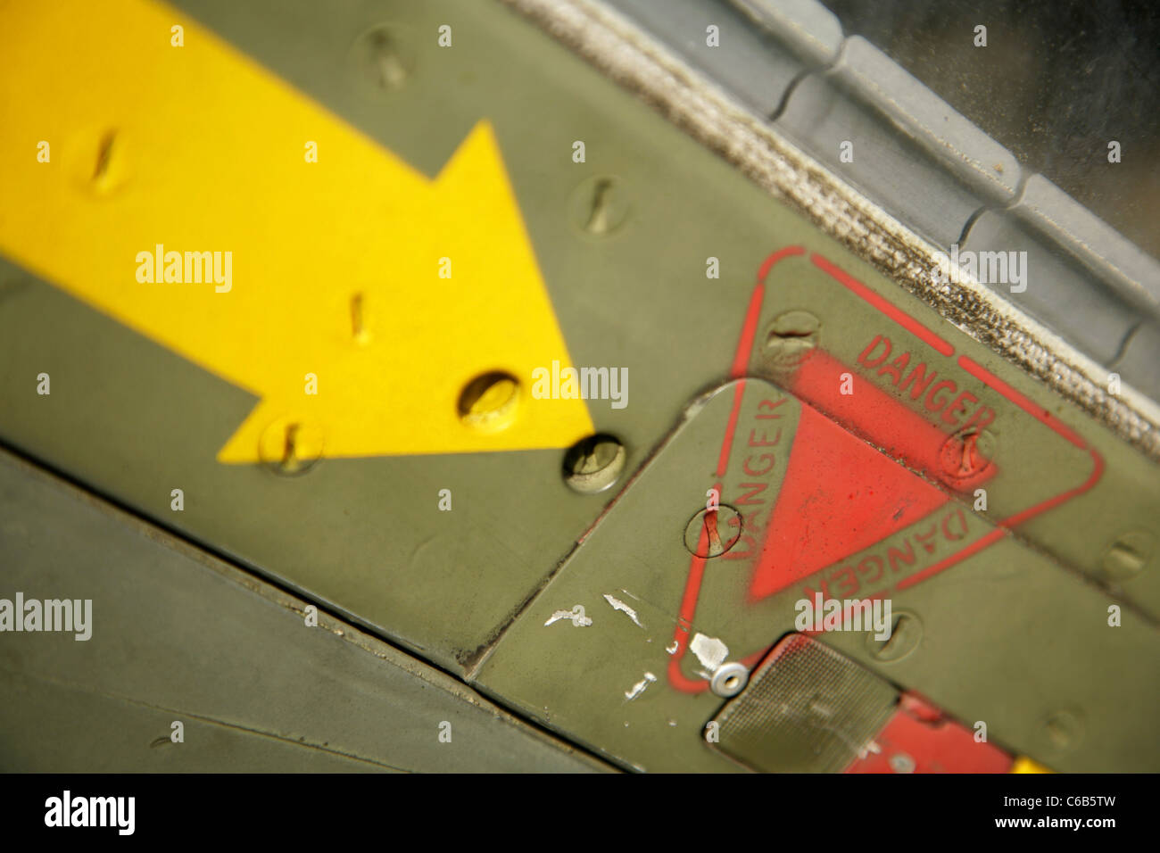 Red danger sign and yellow direction arrow on side of military aircraft ...