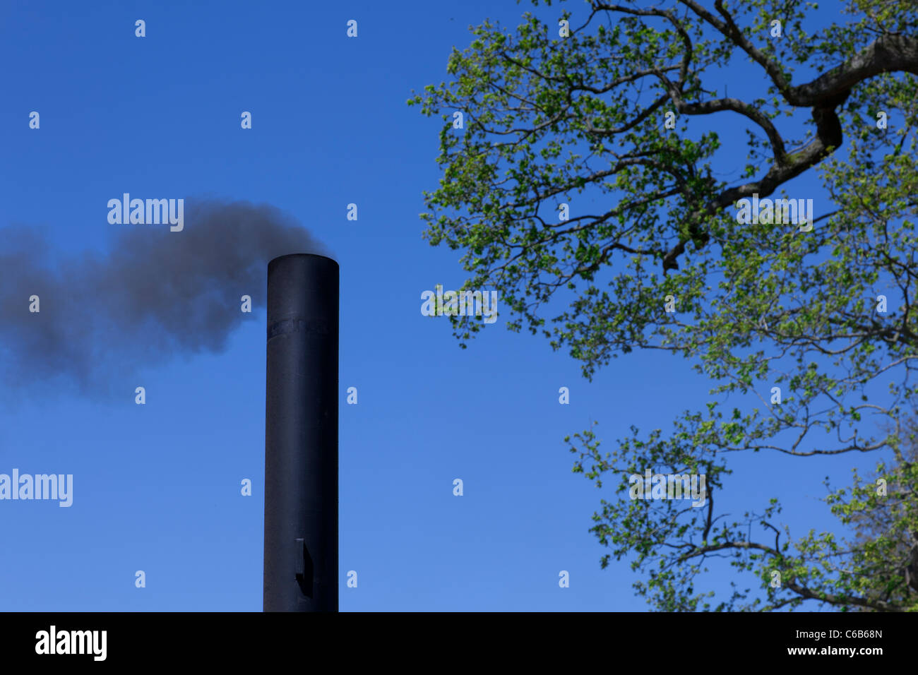 Smoking chimney against blue sky Stock Photo - Alamy