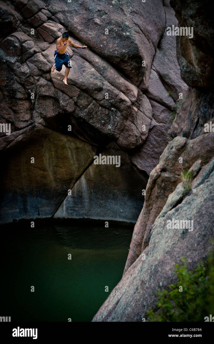 A boy diving off a cliff rock Stock Photo - Alamy