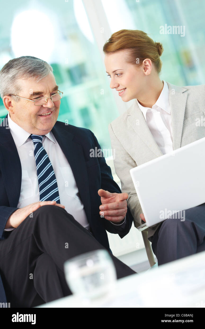 Portrait of boss and employee working with laptop in office Stock Photo ...