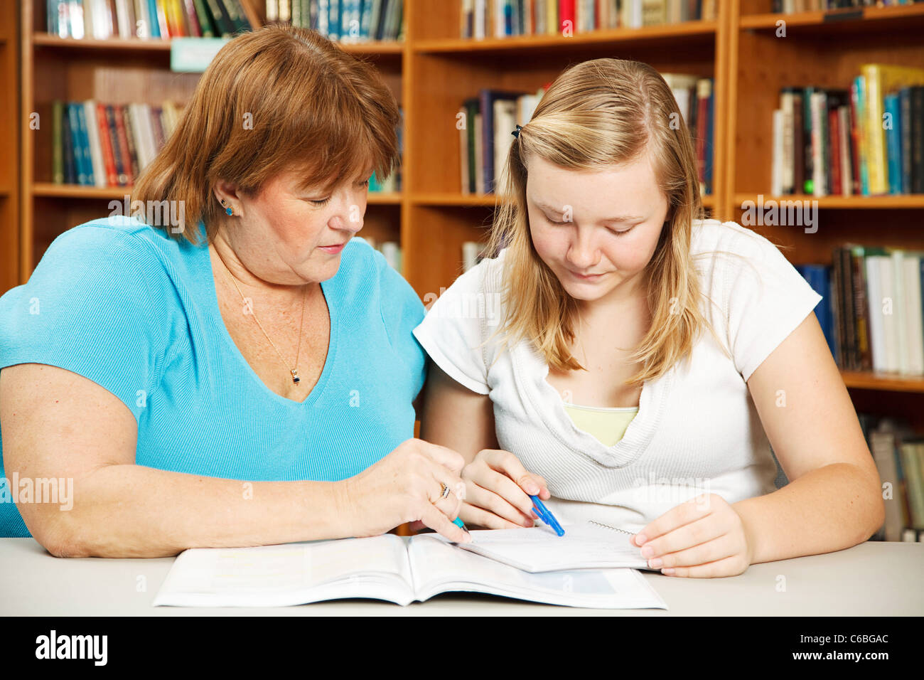 Mother, or teacher, helping a teenage girl with her homework Stock ...