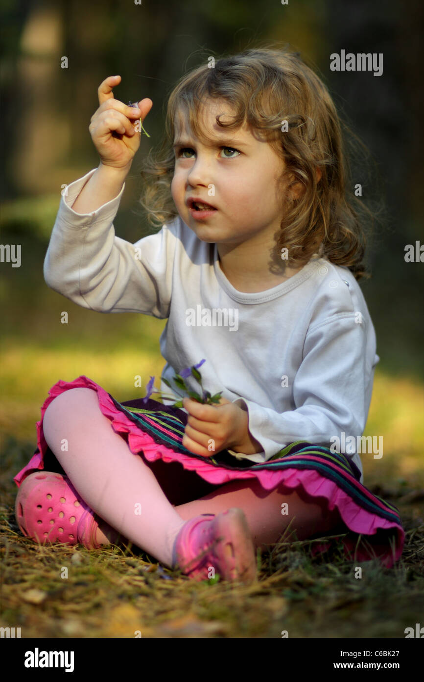 little girl outside with very small flower Stock Photo - Alamy