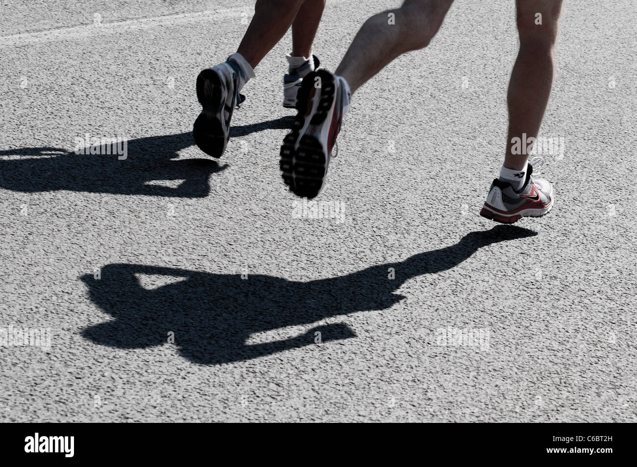 legs of two marathon runners and shadow Stock Photo - Alamy