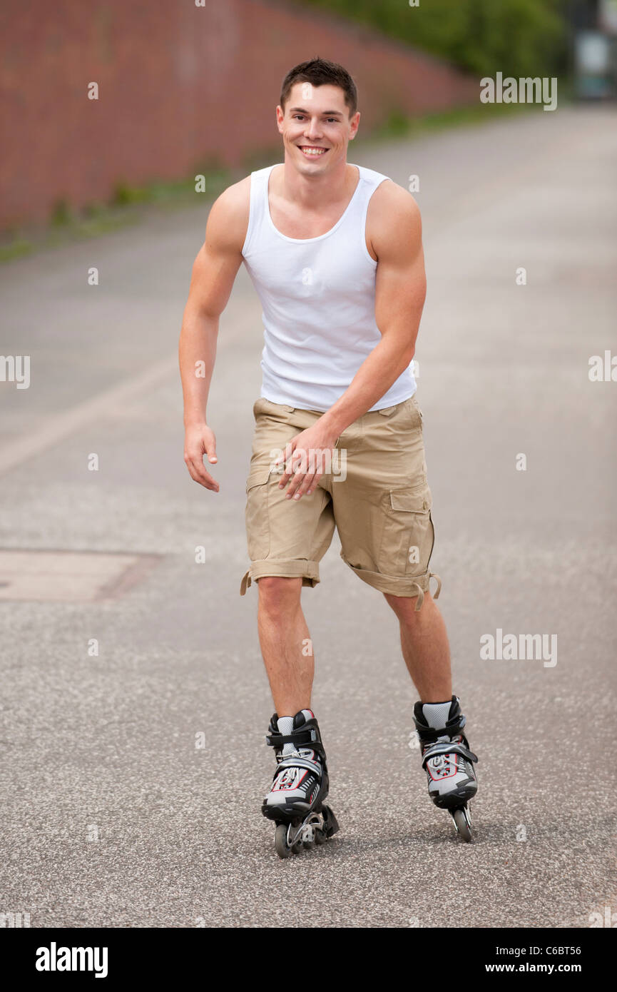 Young and smiling man skating Stock Photo - Alamy