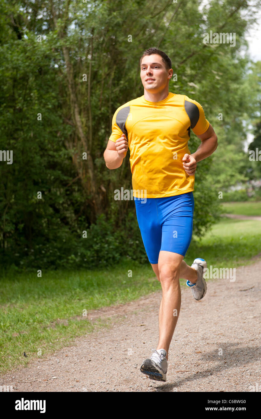 Young and smiling jogger in the park Stock Photo - Alamy