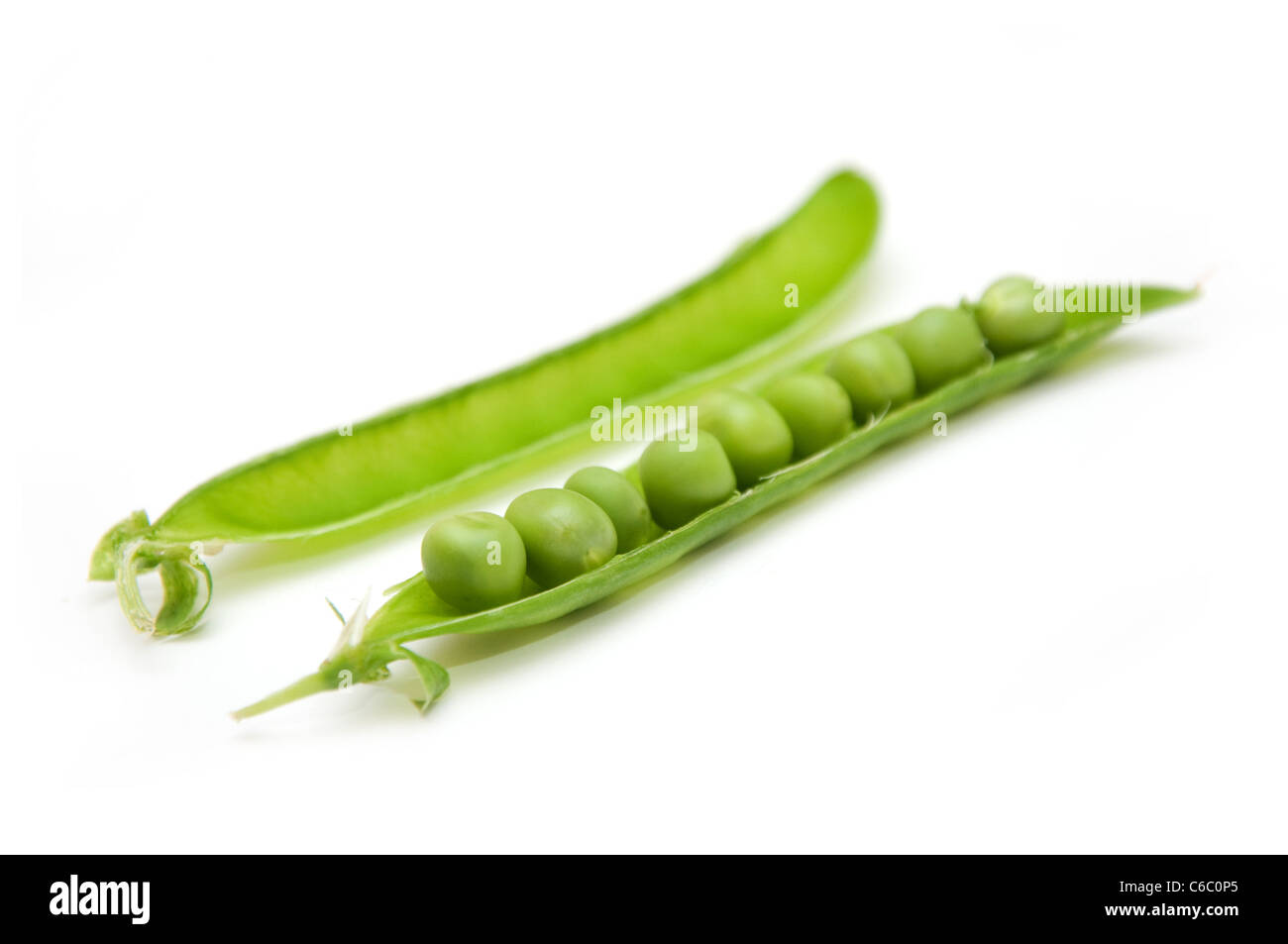 Green peas pods over a white background Stock Photo - Alamy