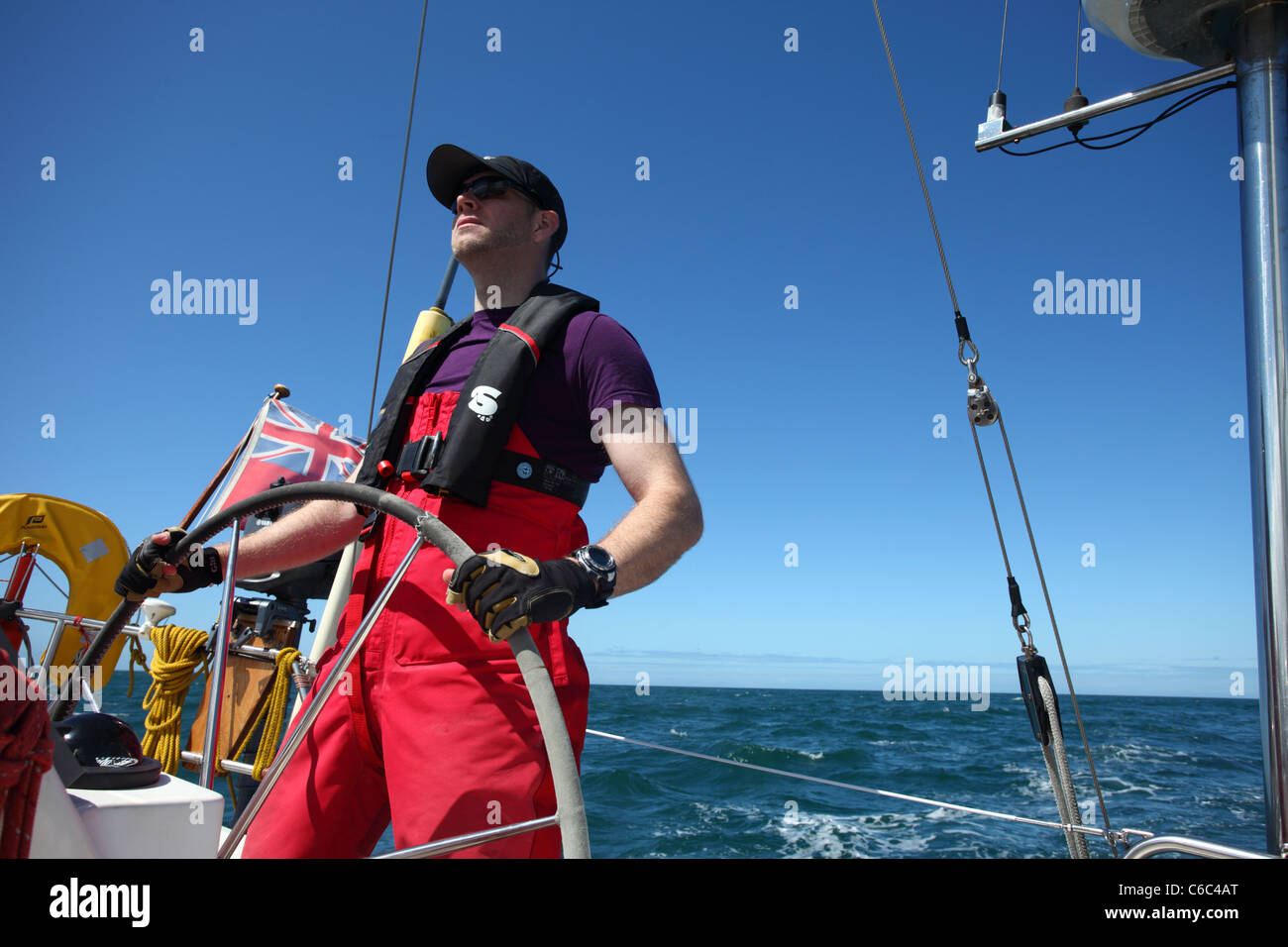man at the helm of a yacht against a blue sky Stock Photo - Alamy