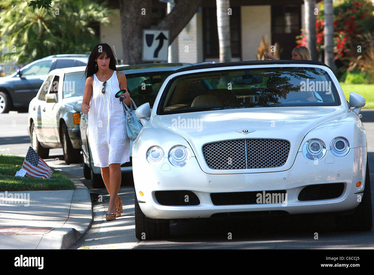 Jennifer Love Hewitt, dressed in a white summer dress and jeweled wedge ...