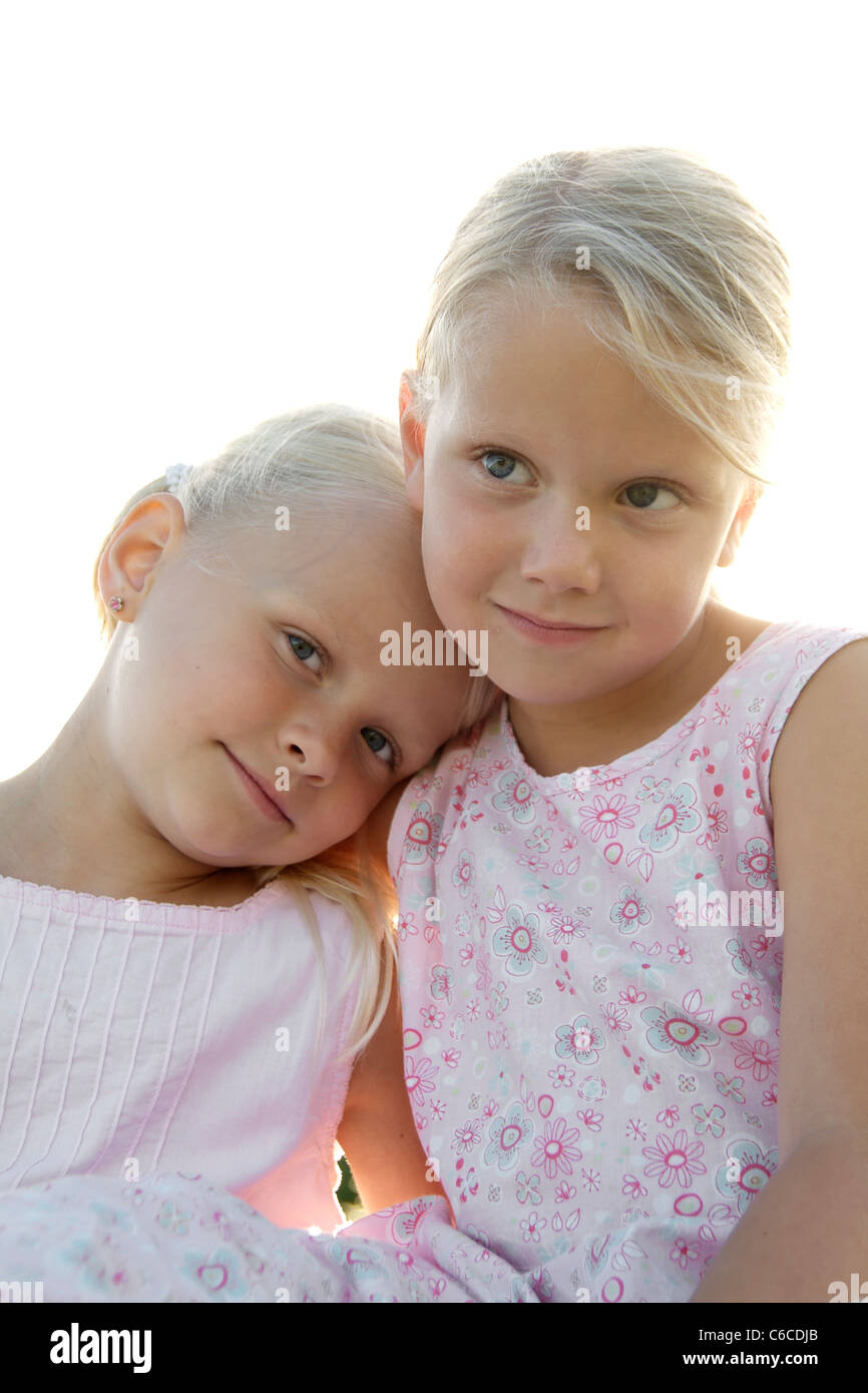 Portrait of two girl friends putting their arms around their shoulders ...