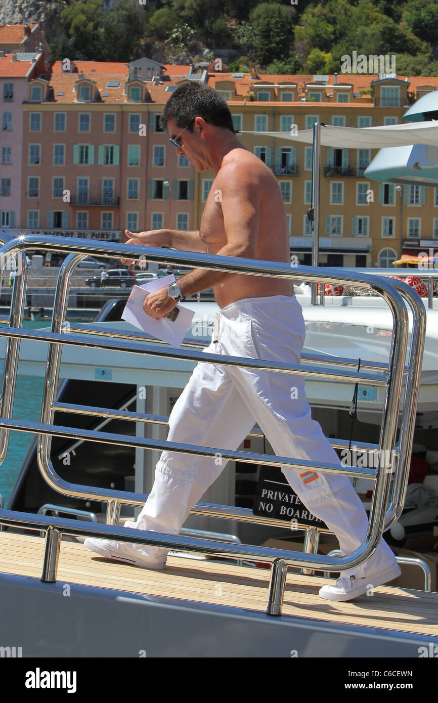 A shirtless Simon Cowell and his fiancee change boats in the port of ...