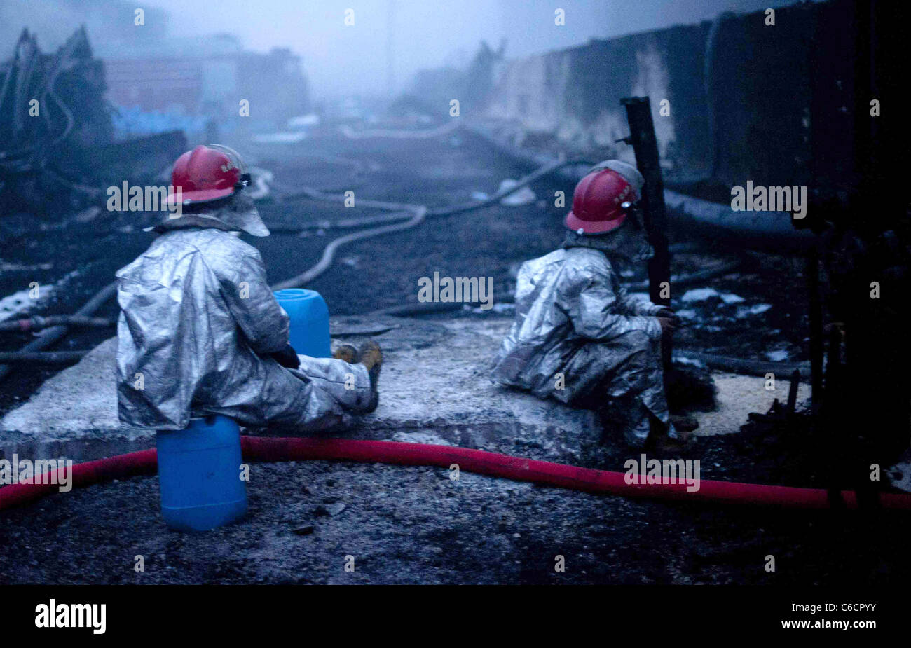 Firefighters try to put out the remaining fire after blasts hit two oil ...