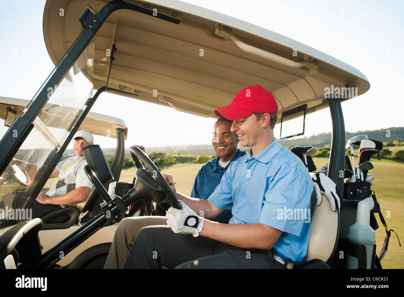 Men driving golf carts on golf course Stock Photo - Alamy