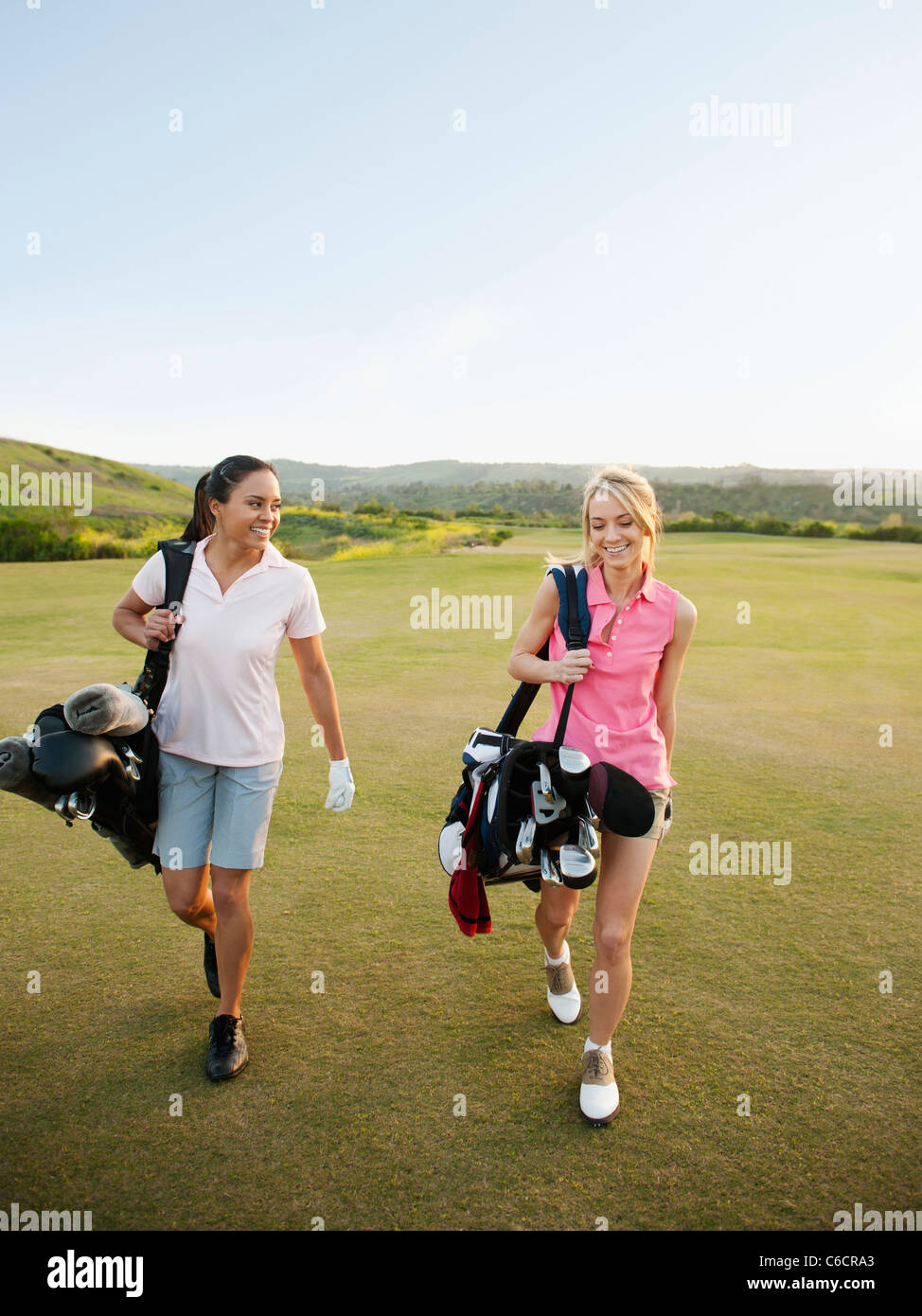 Women carrying golf bags on golf course Stock Photo - Alamy
