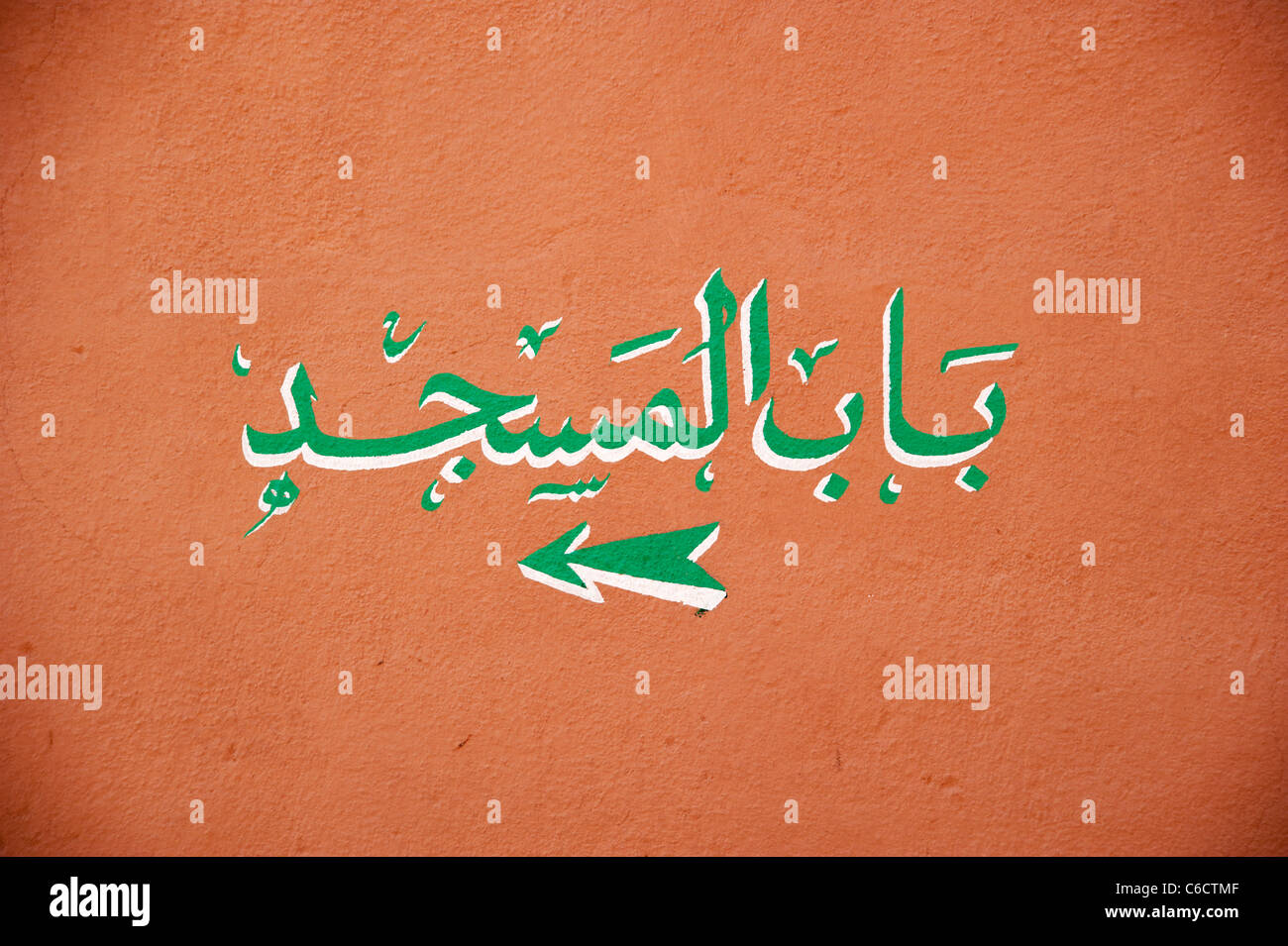 Arabian charakter with direction arrow on a housewall, Morocco, North ...