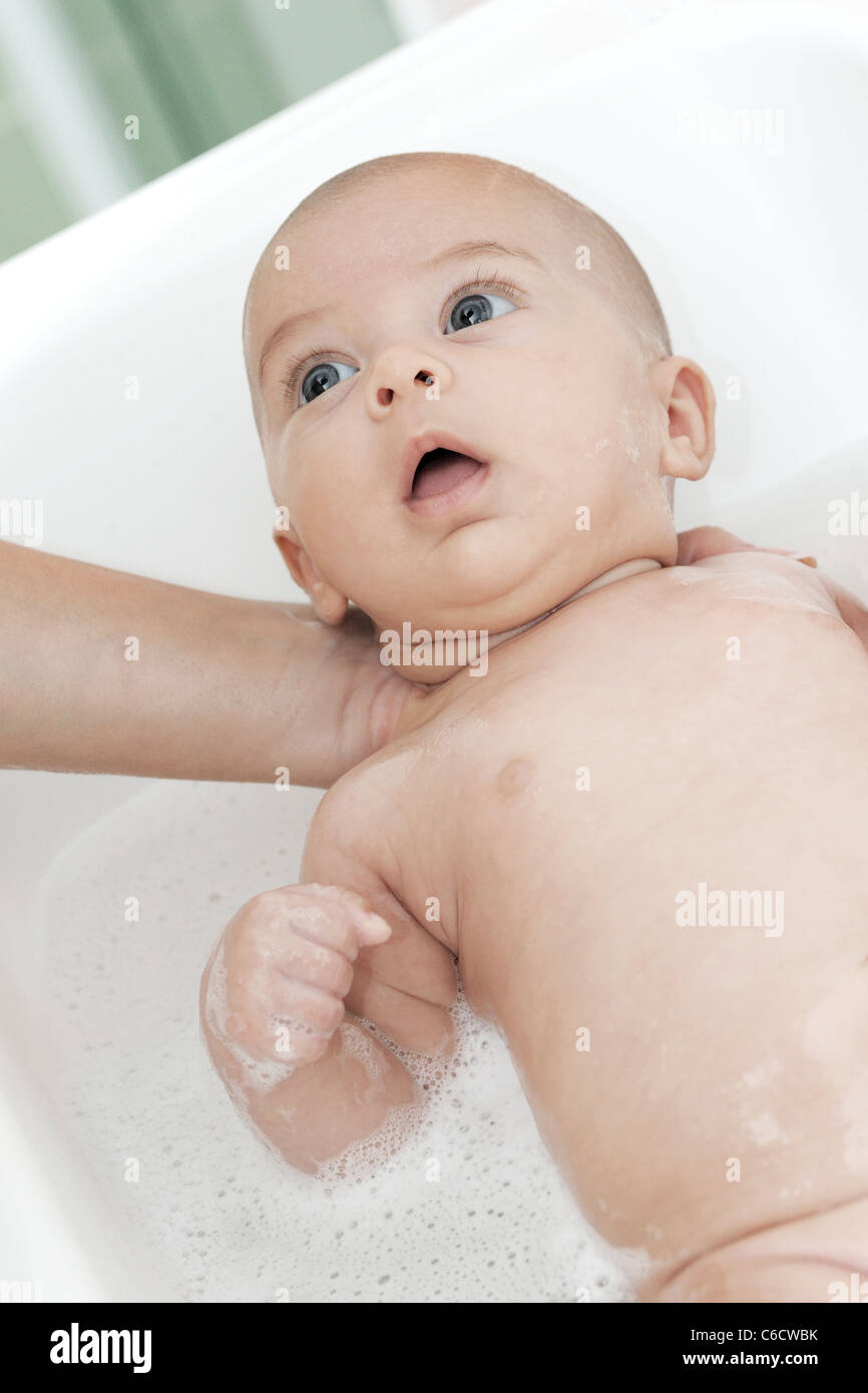baby bath time smiling in the water and watching the mother Stock Photo ...