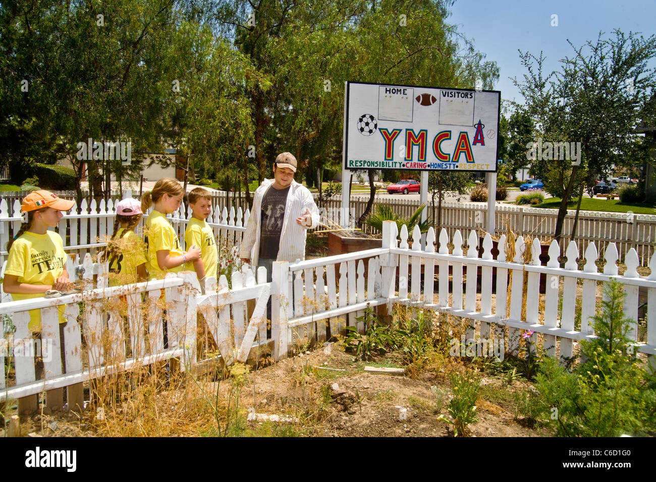 Children volunteers are shown a brush clearing task during an urban ...
