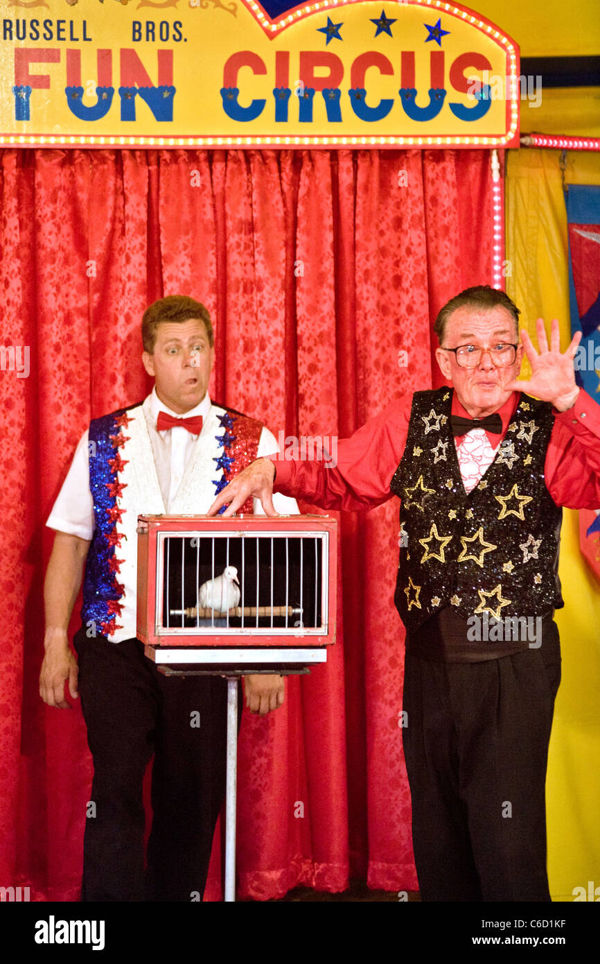 Two magicians prepared a "disappearing dove" act in the amusement park ...