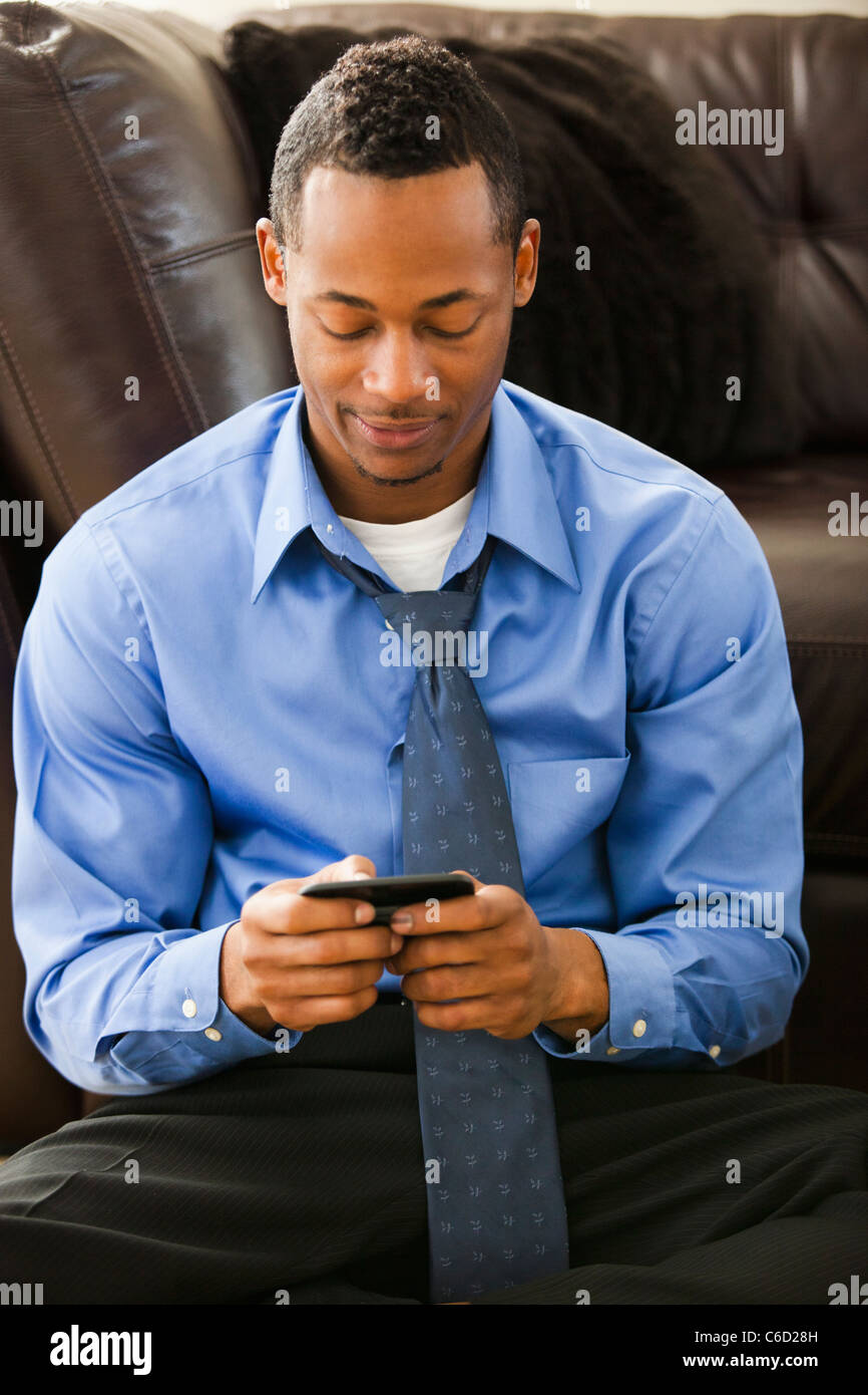 Black businessman text messaging on cell phone Stock Photo - Alamy