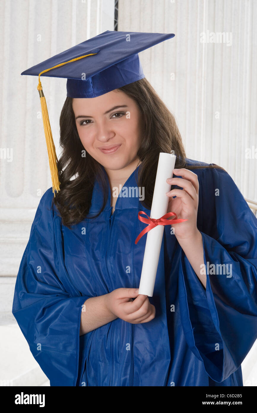 Hispanic teenage girl in graduation cap and gown holding diploma Stock ...