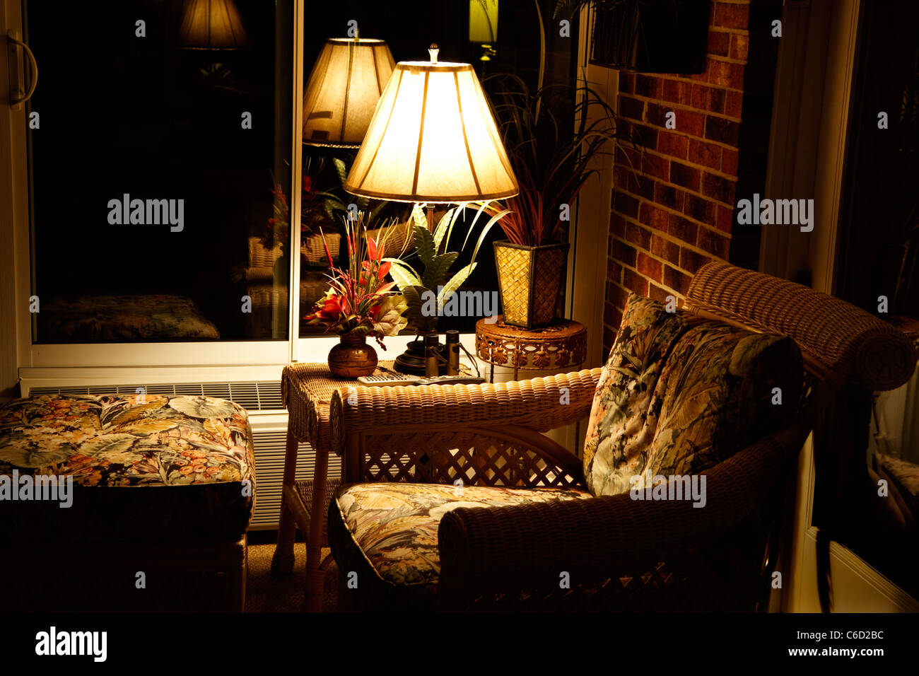 A comfortable, relaxing evening chair and ottoman on a glass-enclosed ...