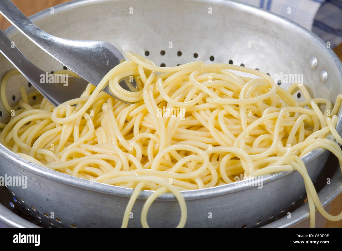 Spaghetti in a tin plate sieve dripping Stock Photo - Alamy