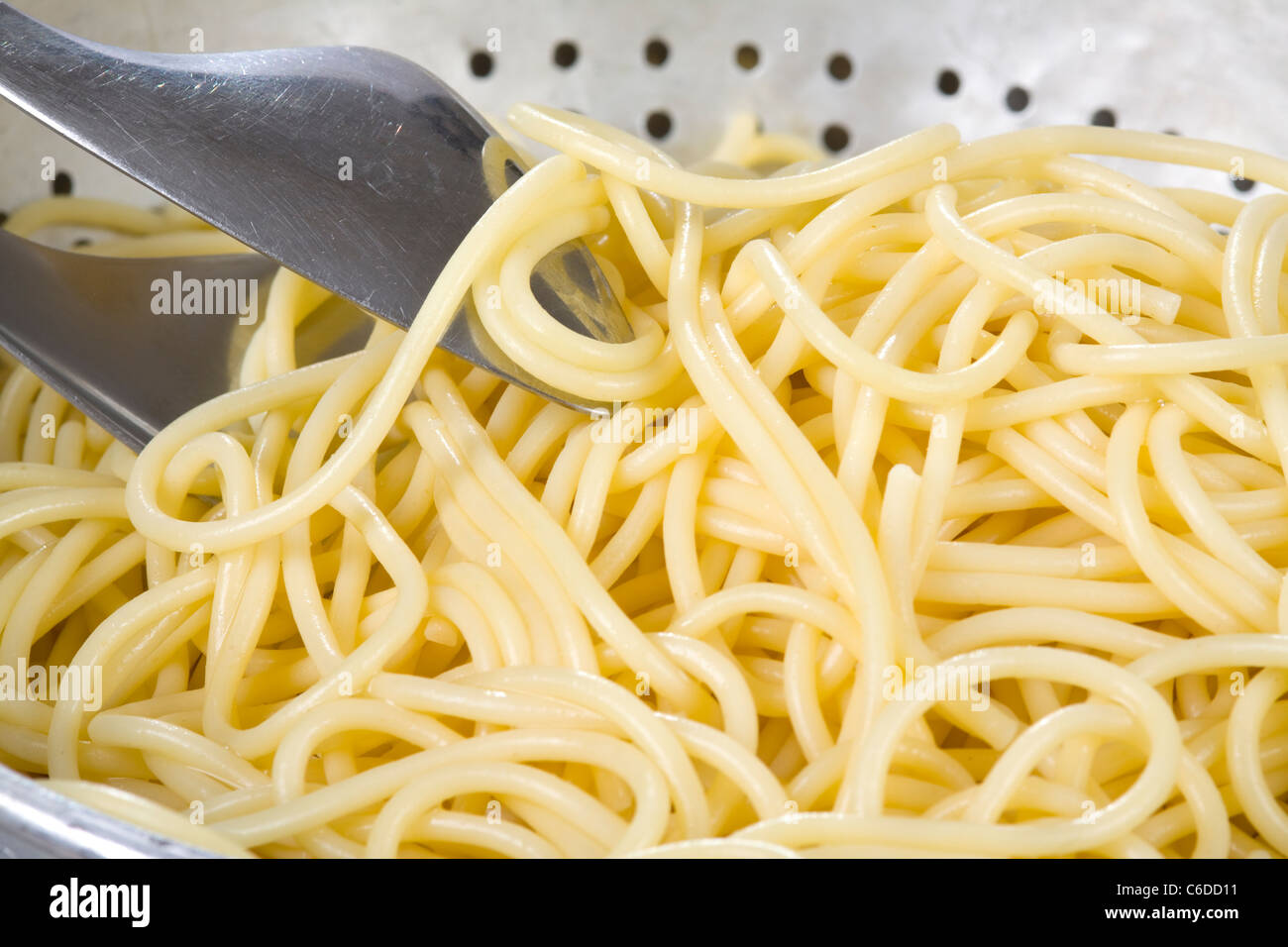 Spaghetti in a tin plate sieve dripping Stock Photo - Alamy