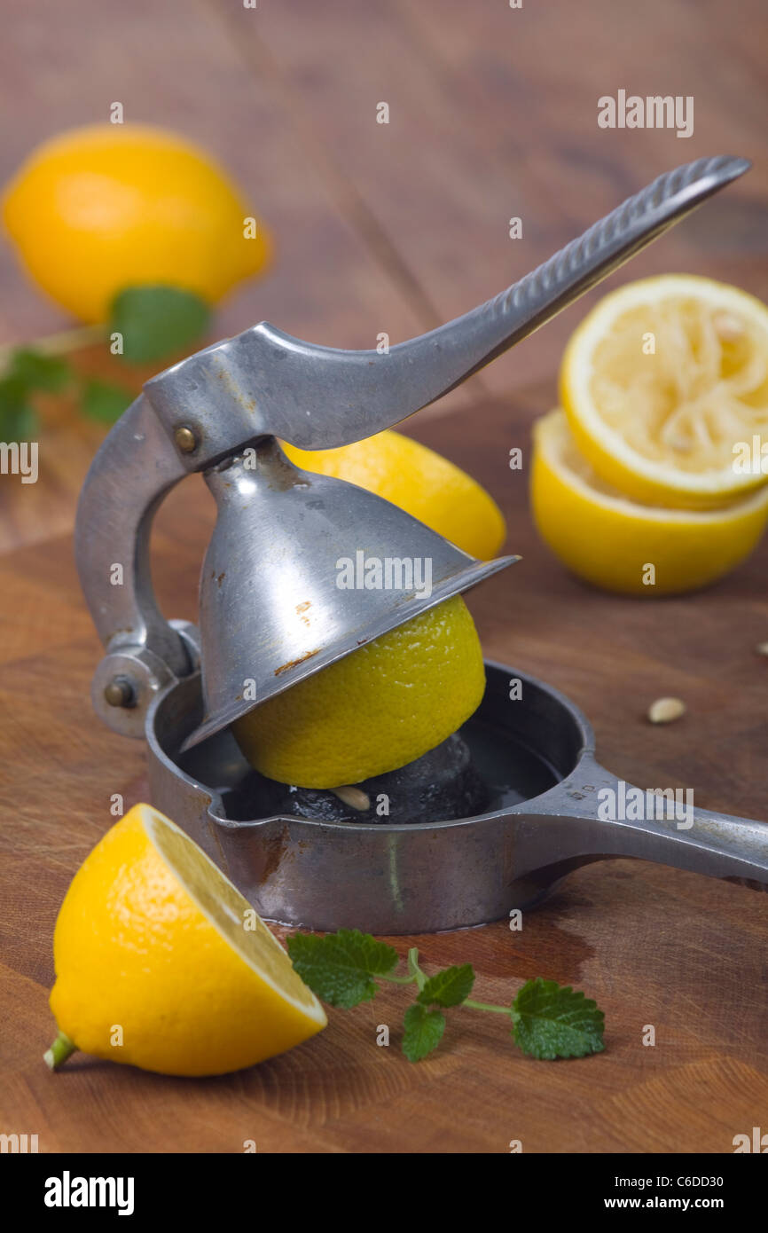 Old lemon squeezer with a lot of lemons Stock Photo - Alamy