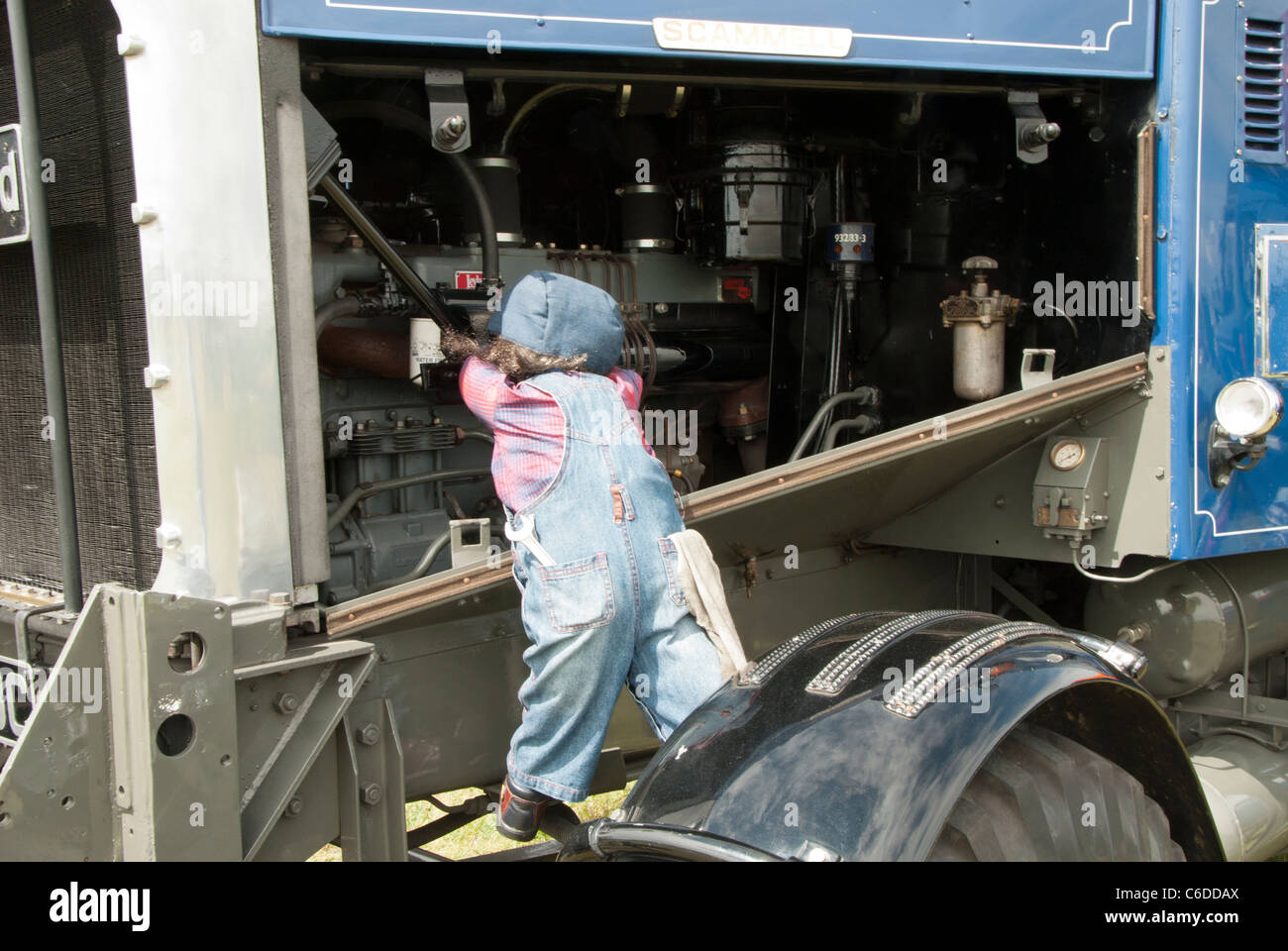A "dummy" dressed as a small child fixing a truck engine shows the ...