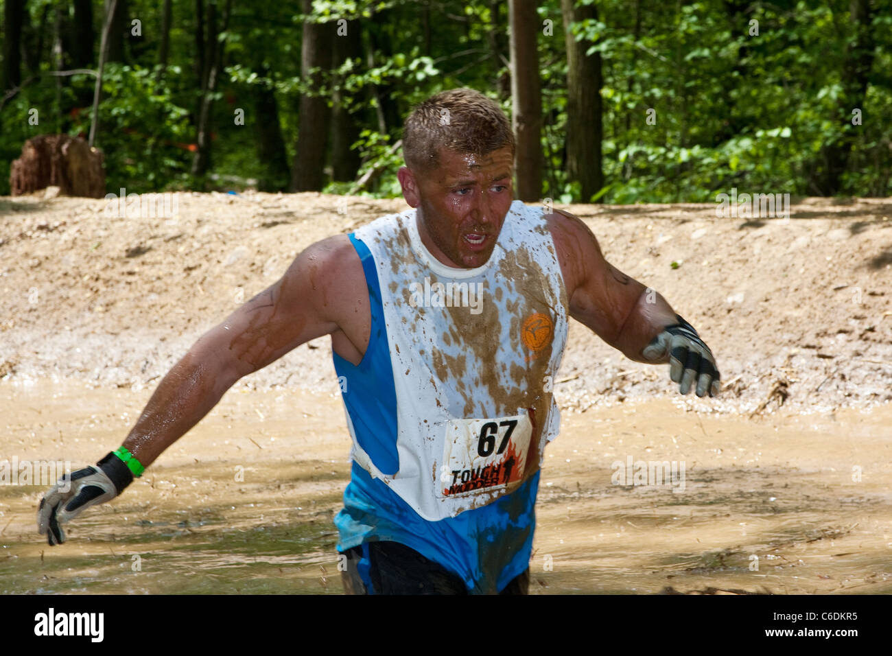 A Tough Mudder participant runs through the 'Swamp Stomp'' section of ...