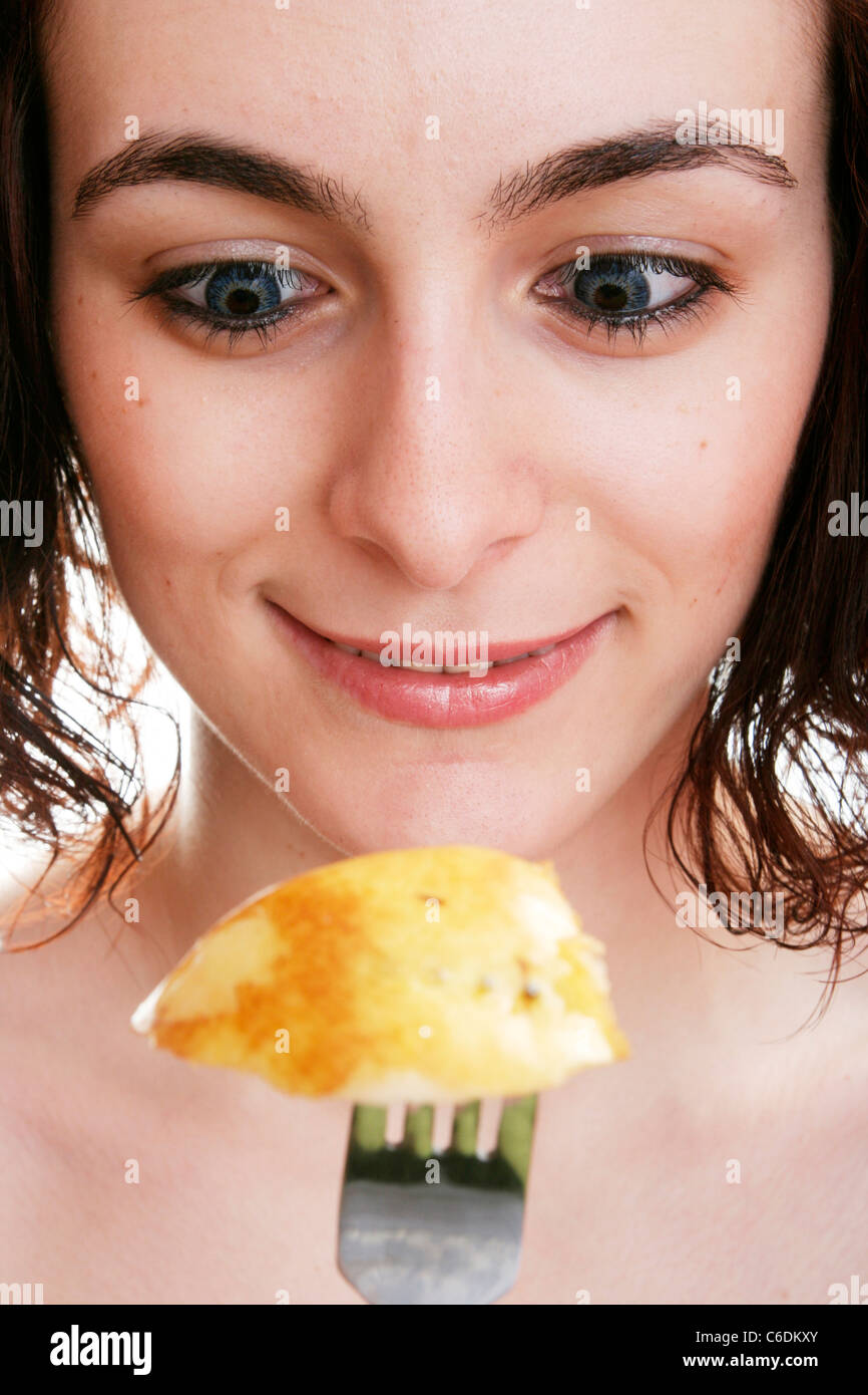 Woman eating tasty pear with fork Stock Photo - Alamy