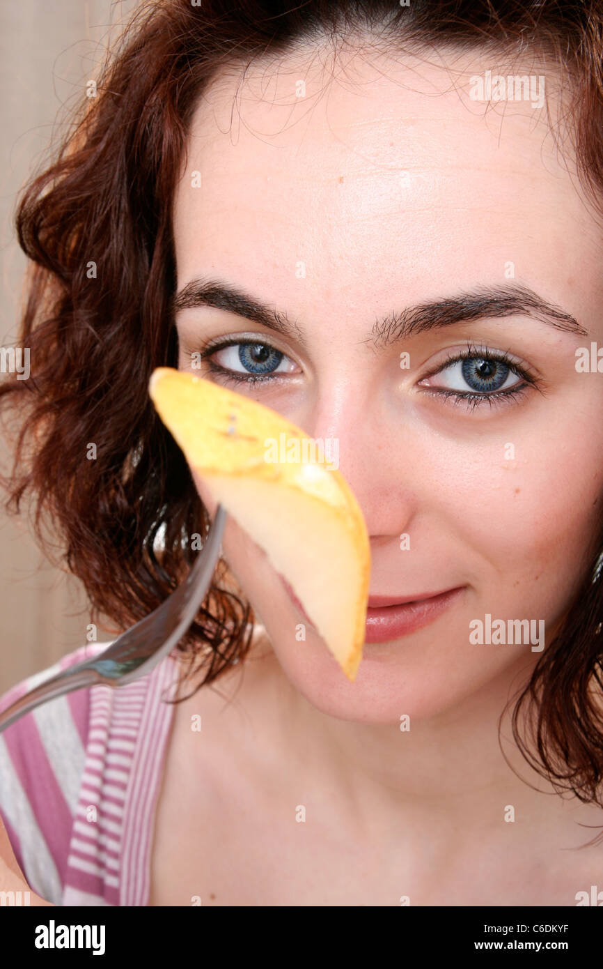 Woman eating tasty pear with fork Stock Photo - Alamy