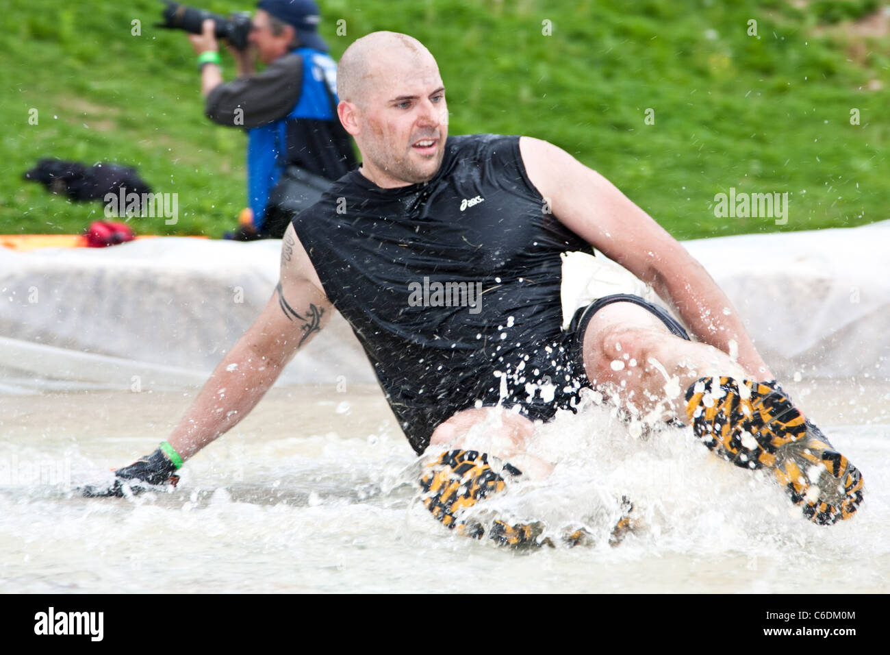 A Tough Mudder participant sliding down the slip n' slip. Tough Mudder ...