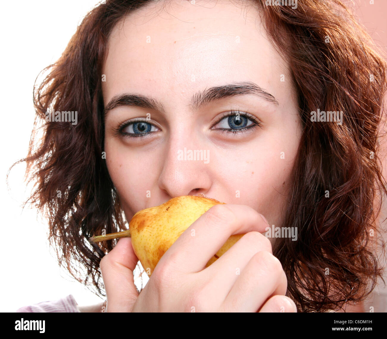 Hungry woman eating a pear Stock Photo - Alamy