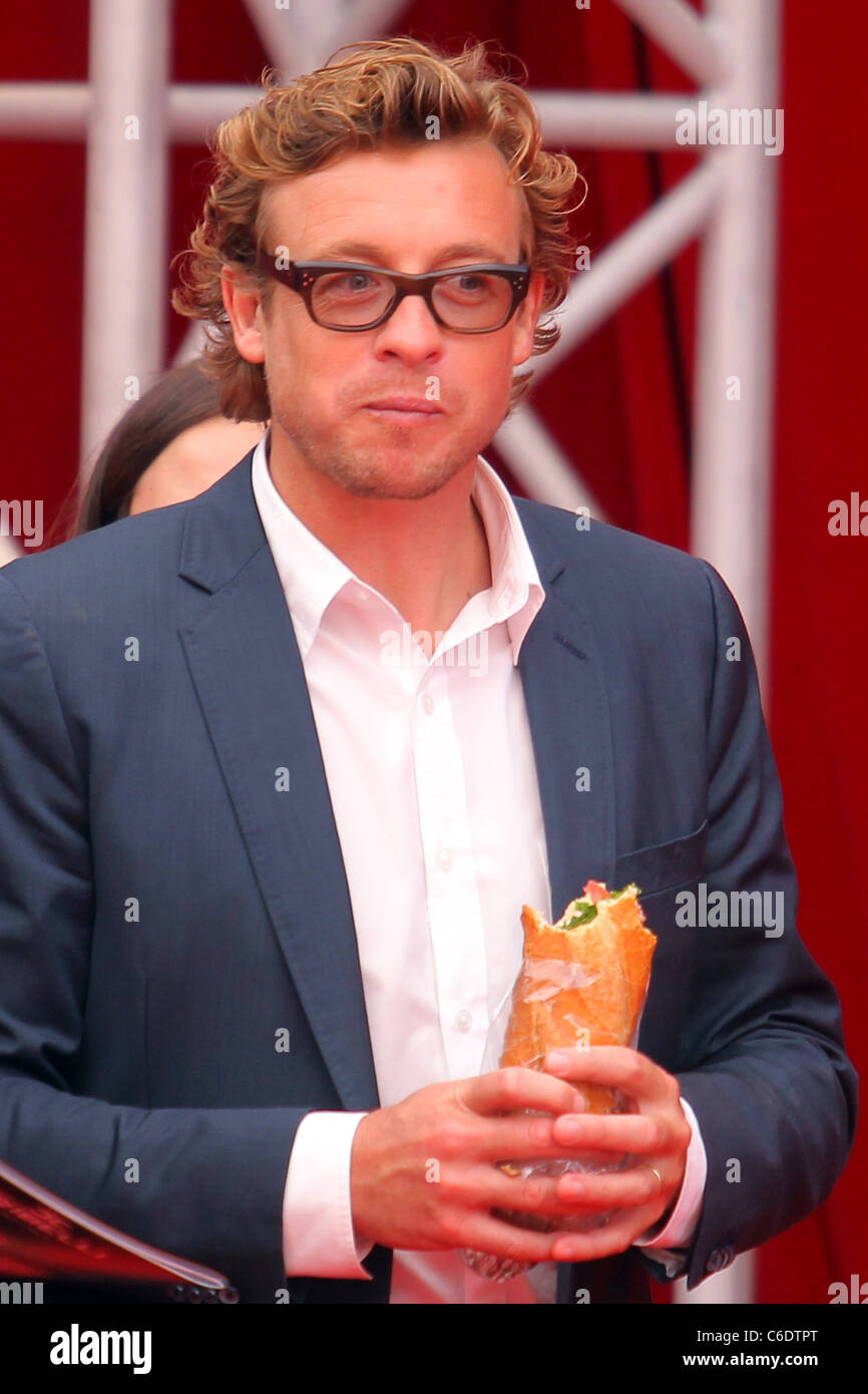 Simon Baker accepts a French sandwich from the press 50th anniversary ...