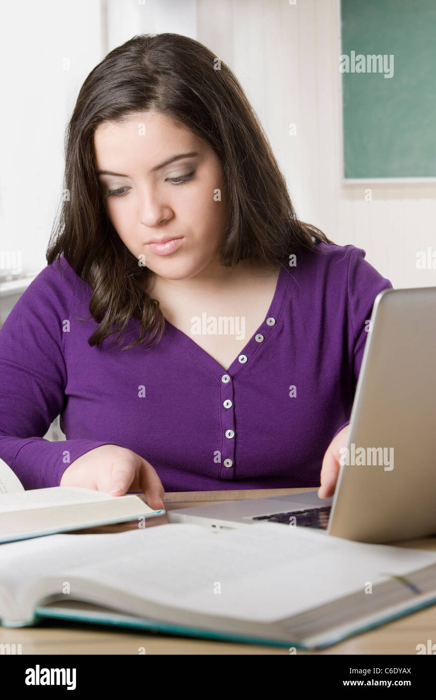 Hispanic teenage girl doing homework with laptop Stock Photo - Alamy