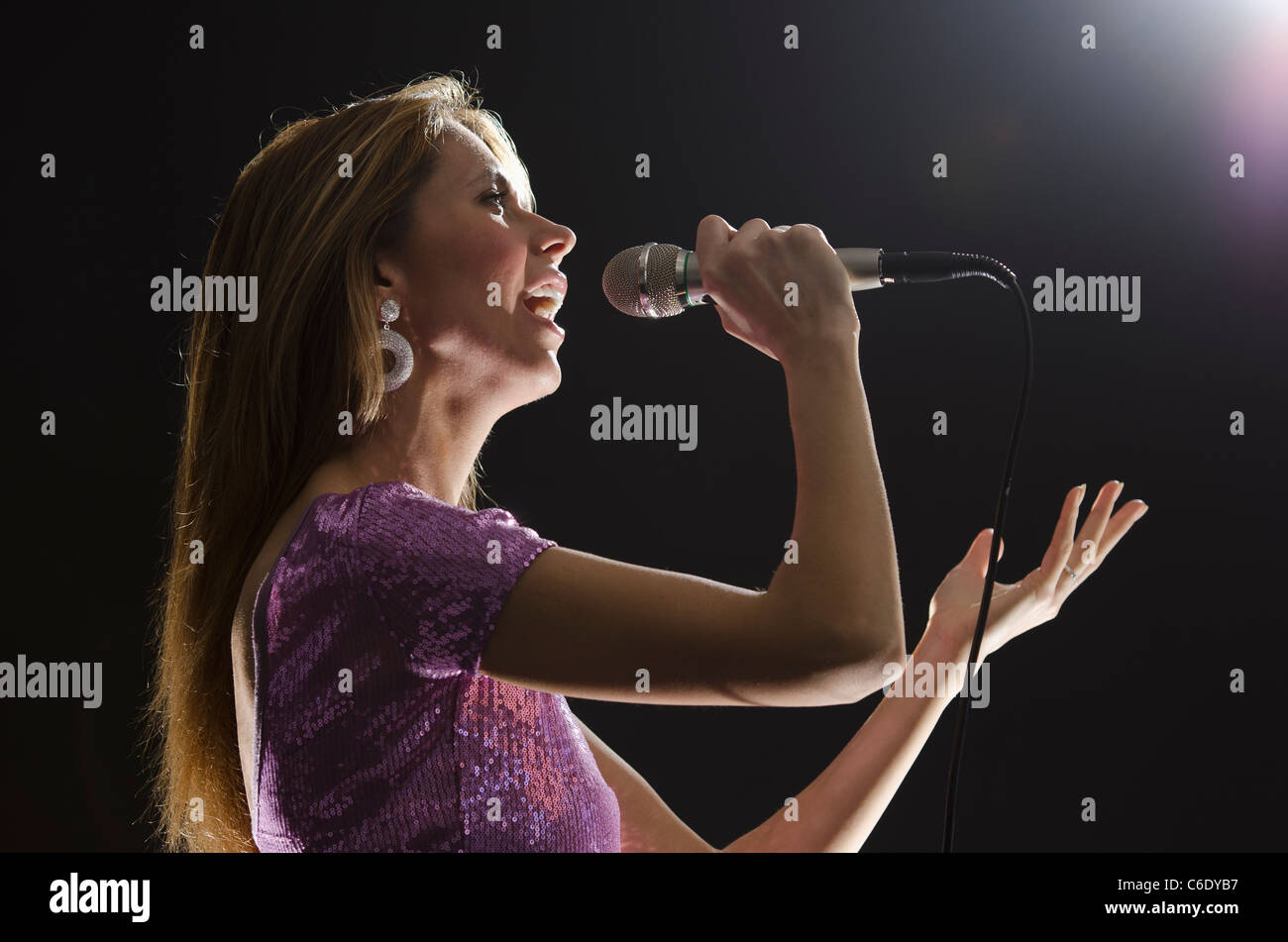 USA, New Jersey, Jersey City, Woman singing in spotlight Stock Photo ...