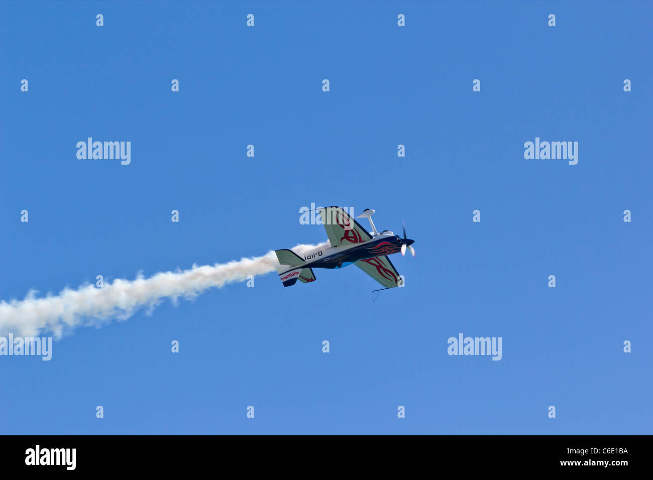 Single inverted Stunt Plane aircraft with smoke trail performing ...