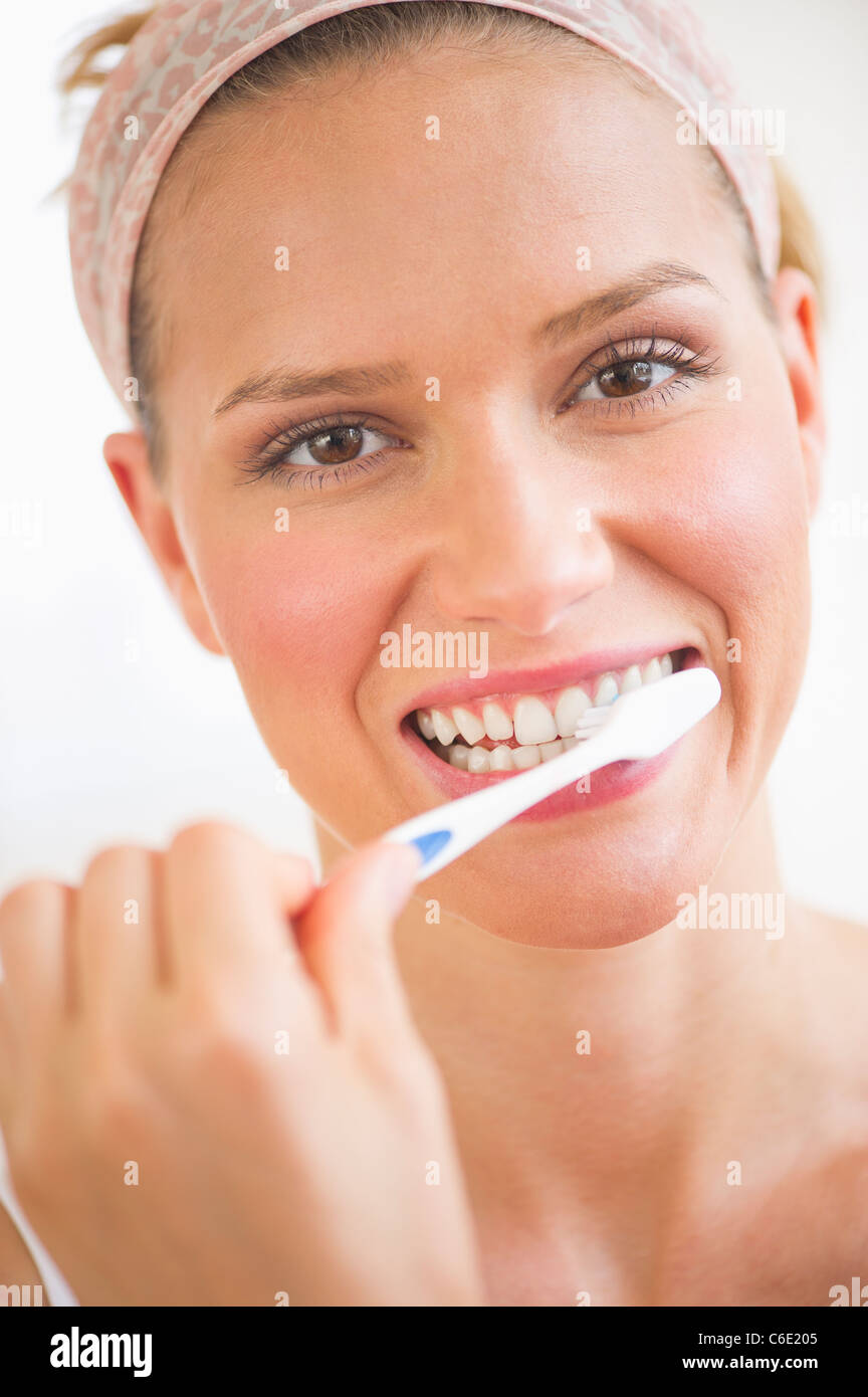 Studio portrait of woman brushing teeth Stock Photo - Alamy