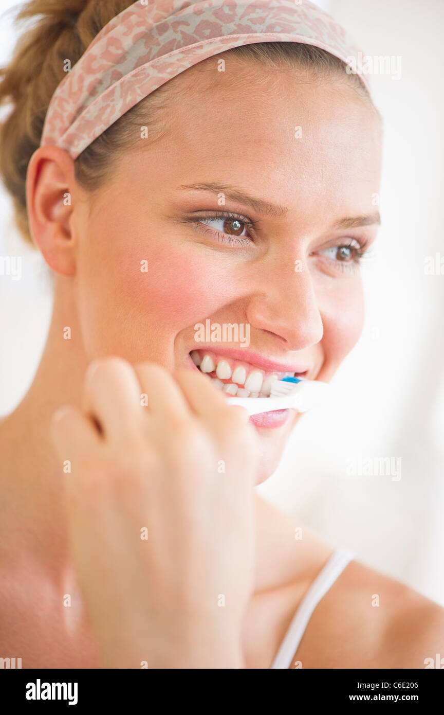 Studio portrait of woman brushing teeth Stock Photo - Alamy