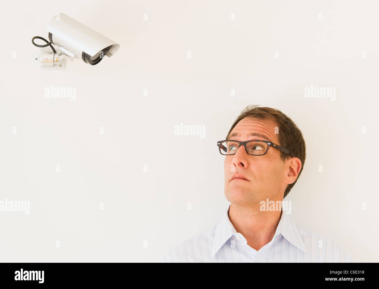Businessman under surveillance of security camera Stock Photo - Alamy