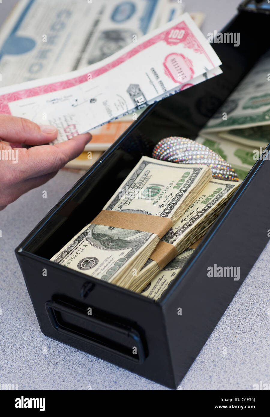 Hand inserting valuables into safe deposit box Stock Photo - Alamy