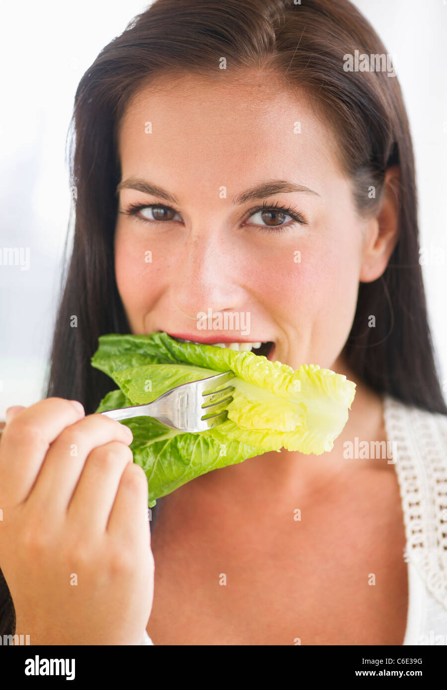 Portrait of woman eating lettuce Stock Photo - Alamy