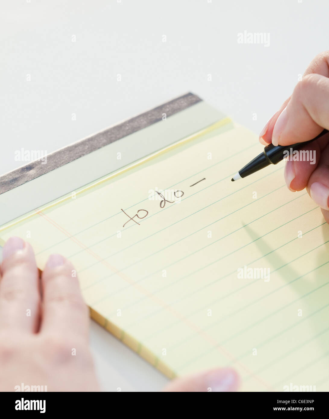 USA, New Jersey, Jersey City, Close up of woman's hands writing list of ...
