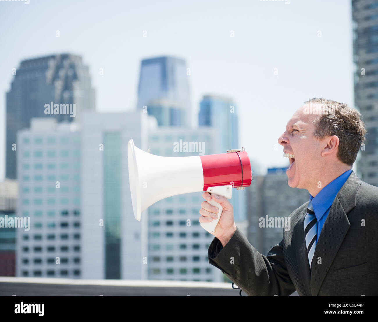 USA, New Jersey, Jersey City, Businessman shouting through megaphone ...